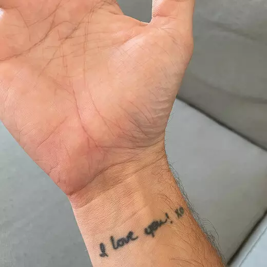 Il braccio dell'uomo con ti amo tatuato sul polso