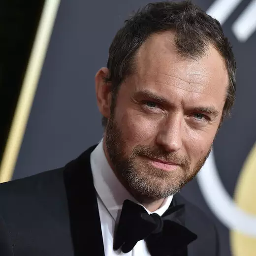 Jude Law ta headshot inda actor yana da rubutu a saman salon gyara gashi.